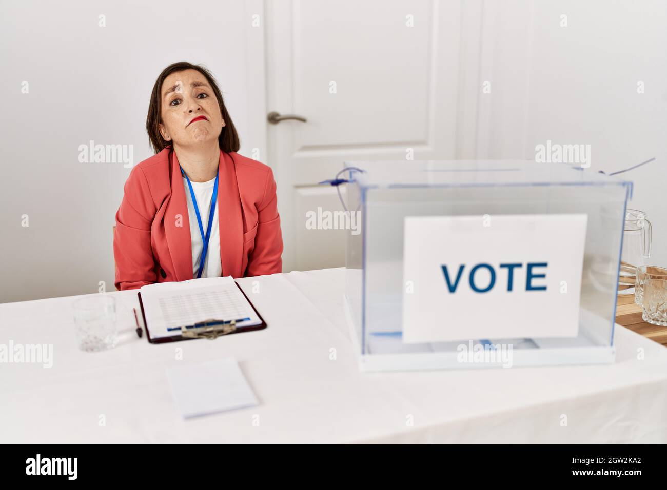 Beautiful middle age hispanic woman at political election sitting by ...