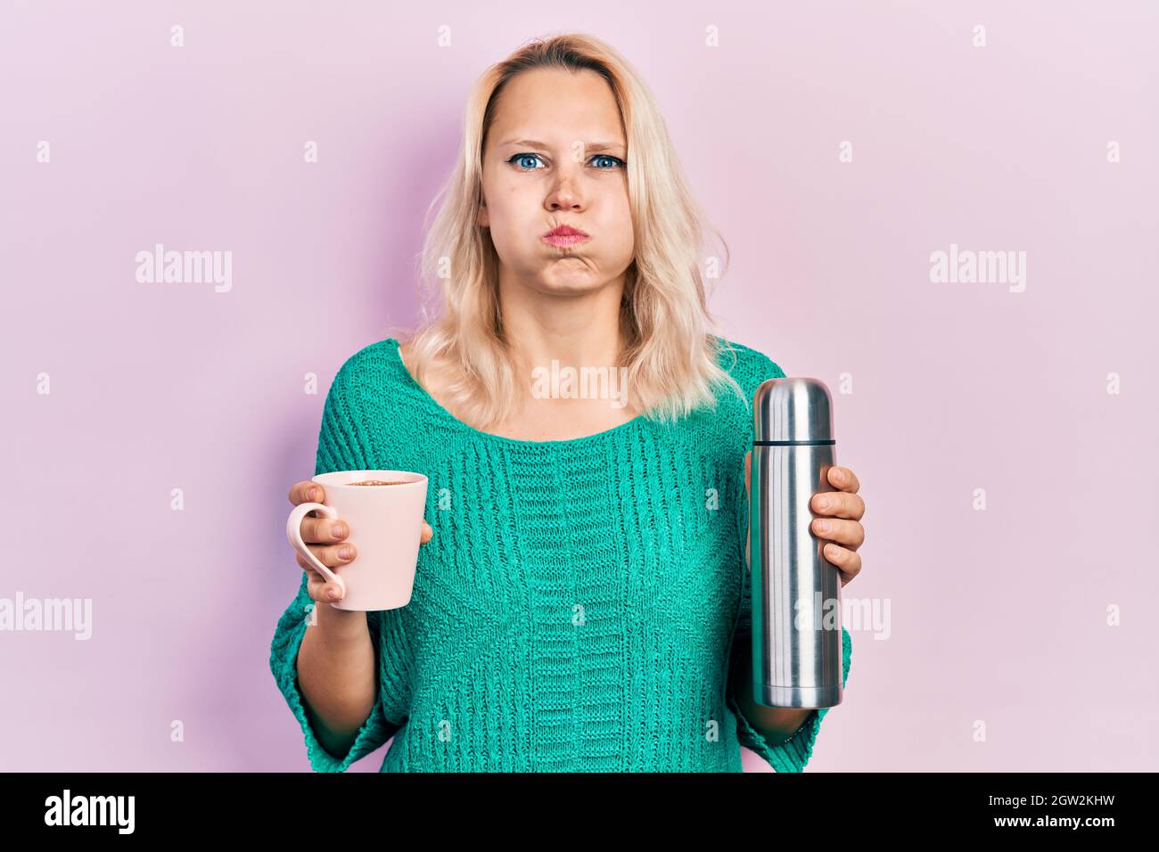 Beautiful caucasian blonde woman drinking a cup of coffee holding ...
