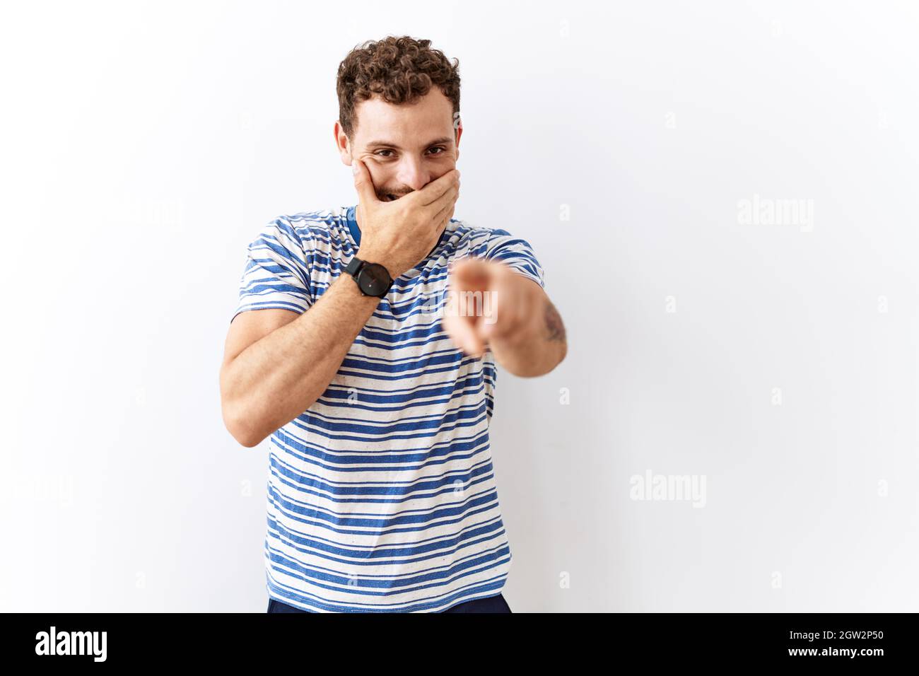 Handsome young man standing over isolated background laughing at you ...