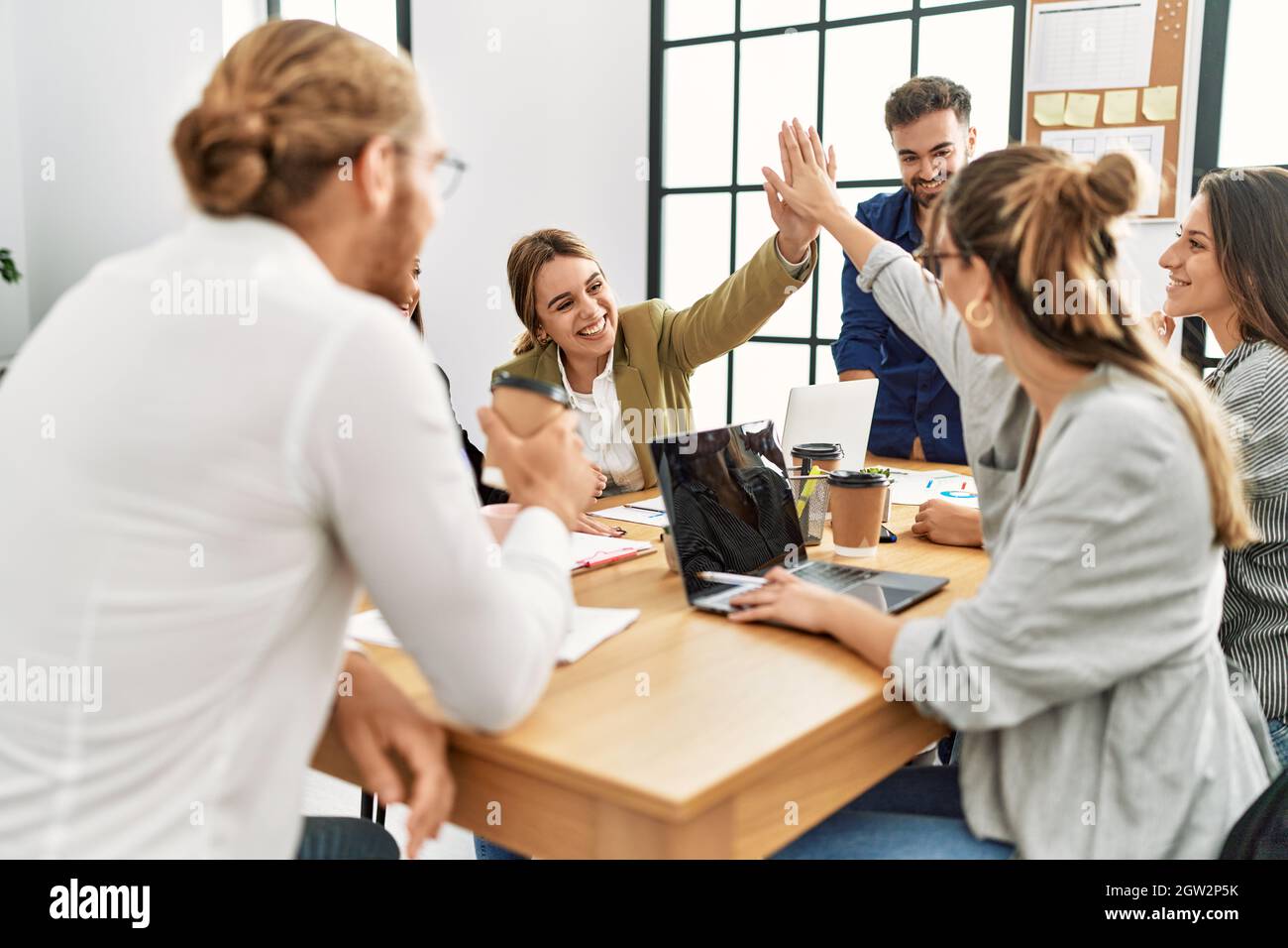 Two workers smiling happy high five during meeting at the office Stock ...