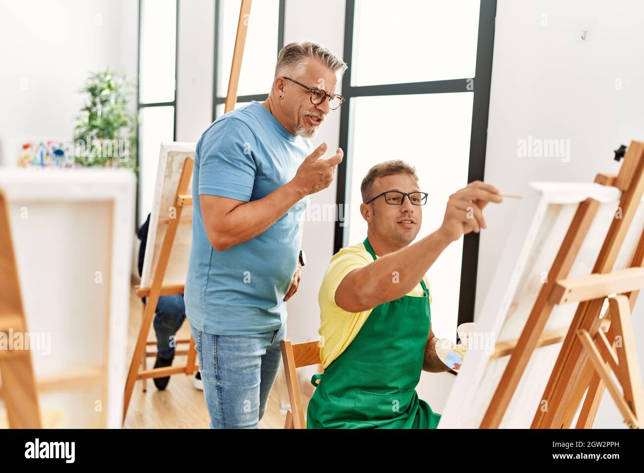 Group of middle age paint students drawing at art studio. Teacher with ...
