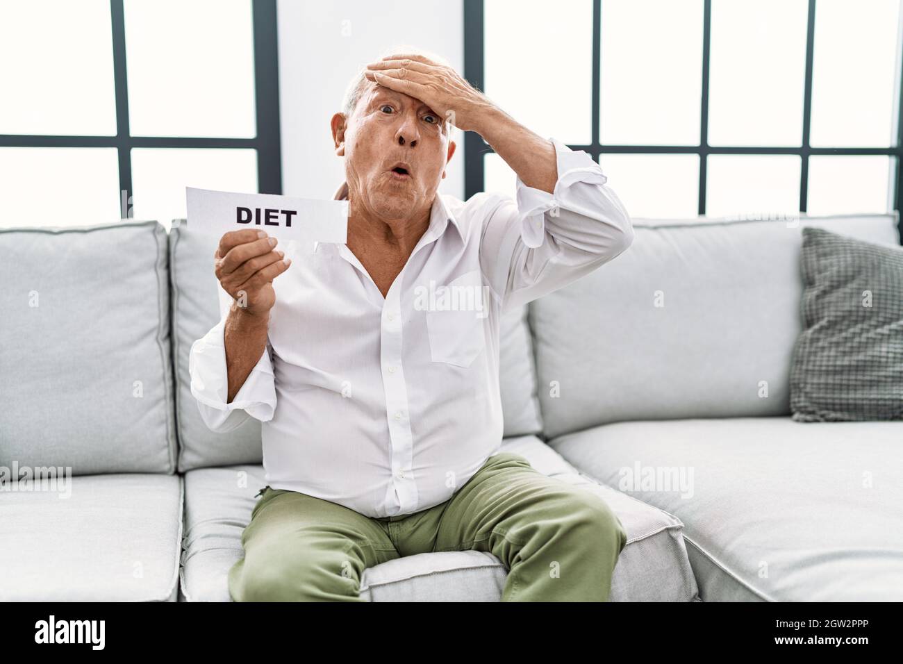 Senior man holding diet banner stressed and frustrated with hand on ...