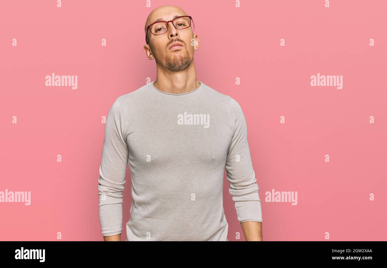 Bald man with beard wearing casual clothes and glasses relaxed with ...
