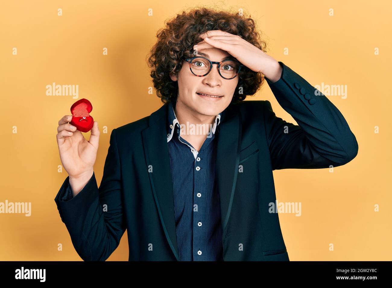 Handsome young man holding engagement ring for proposal stressed and ...
