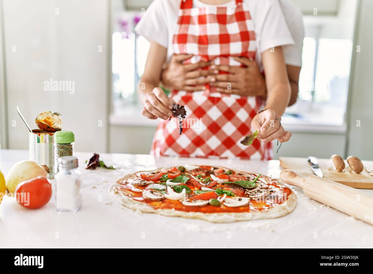 Couple hugging and cooking italian pizza at kitchen Stock Photo - Alamy