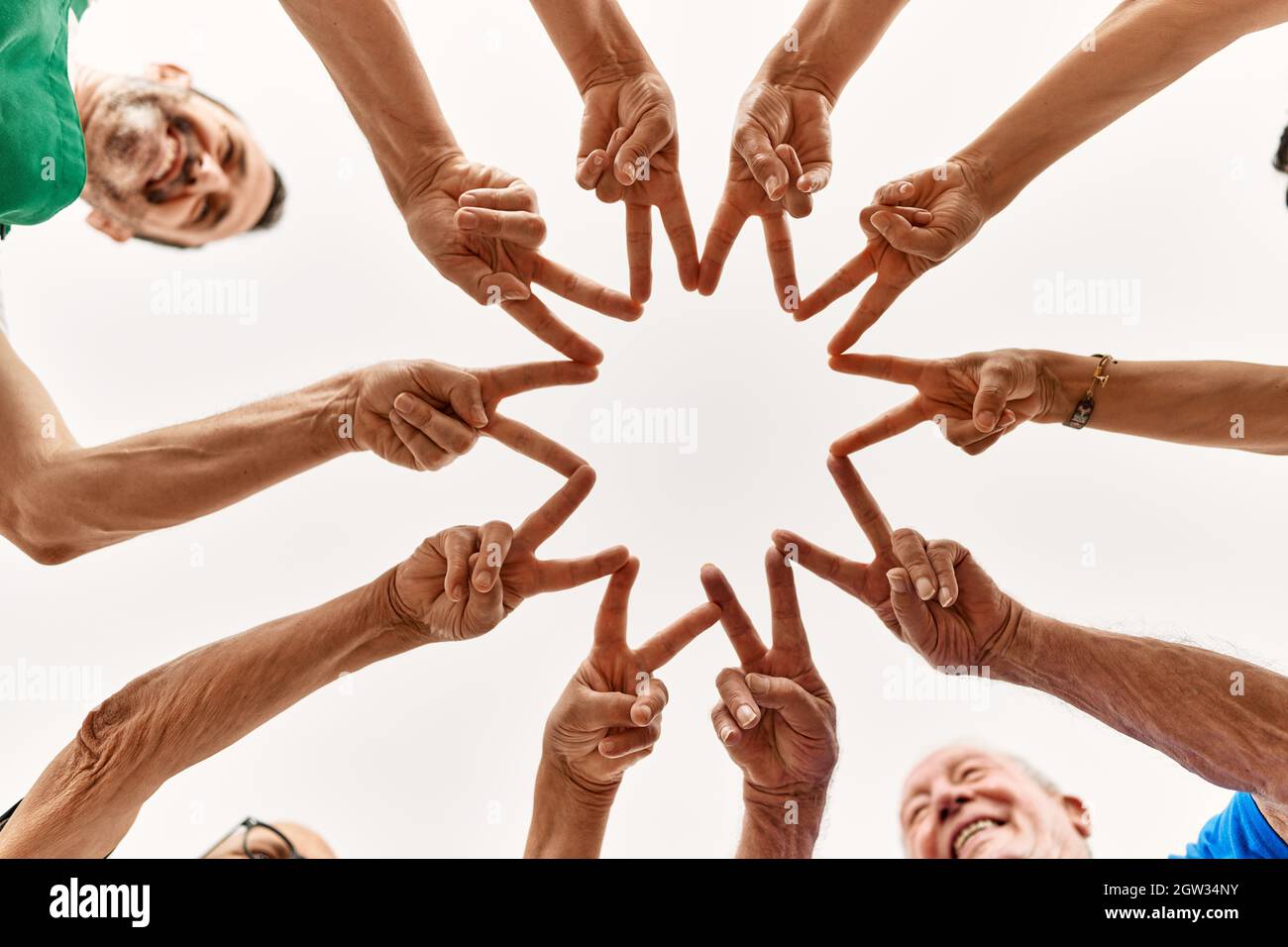Group of middle age friends doing victory sign with fingers and hands ...