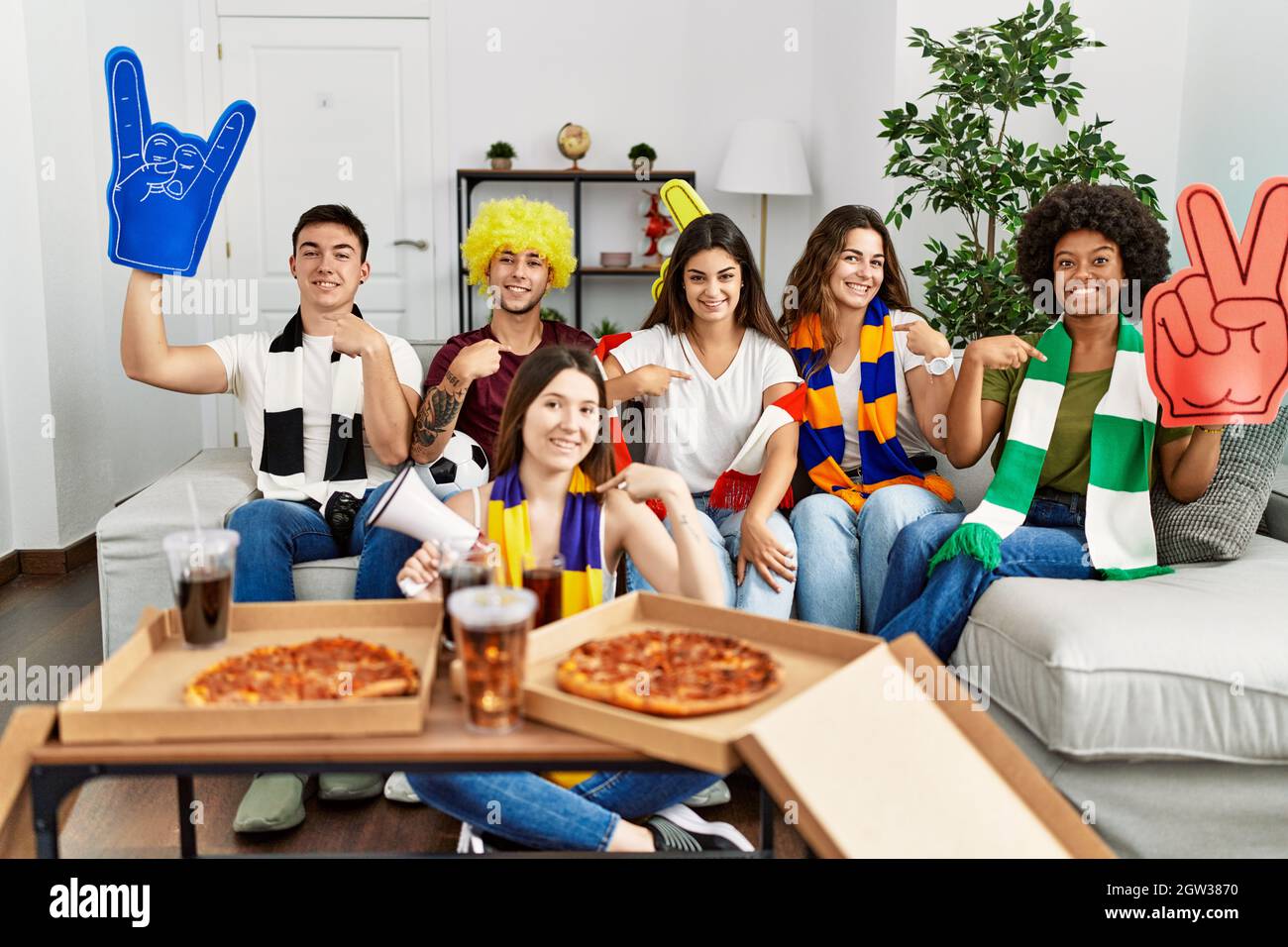 Group of young people wearing team scarf cheering football game ...