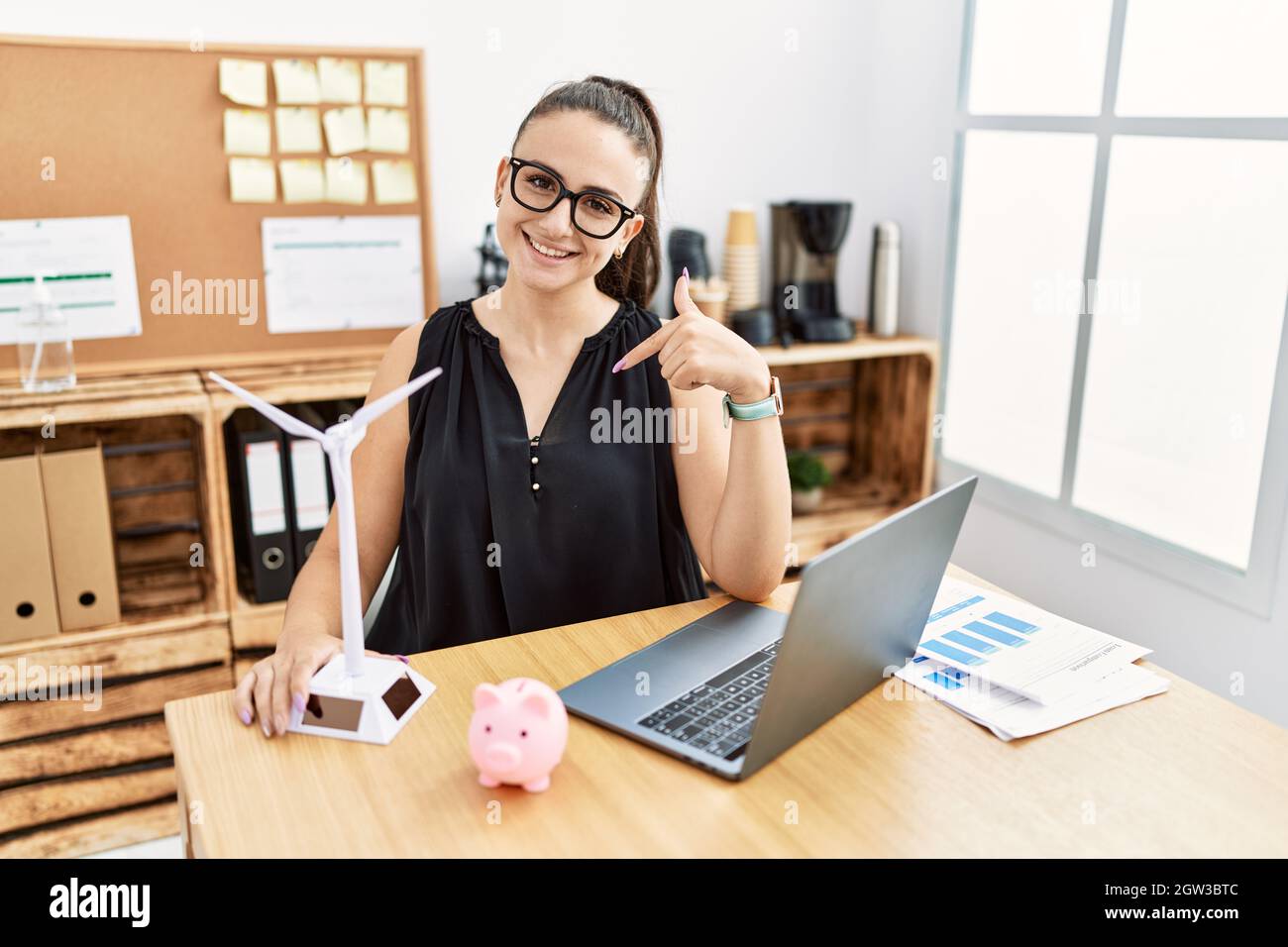 Young brunette woman working on solar windmill for cheaper electricity ...