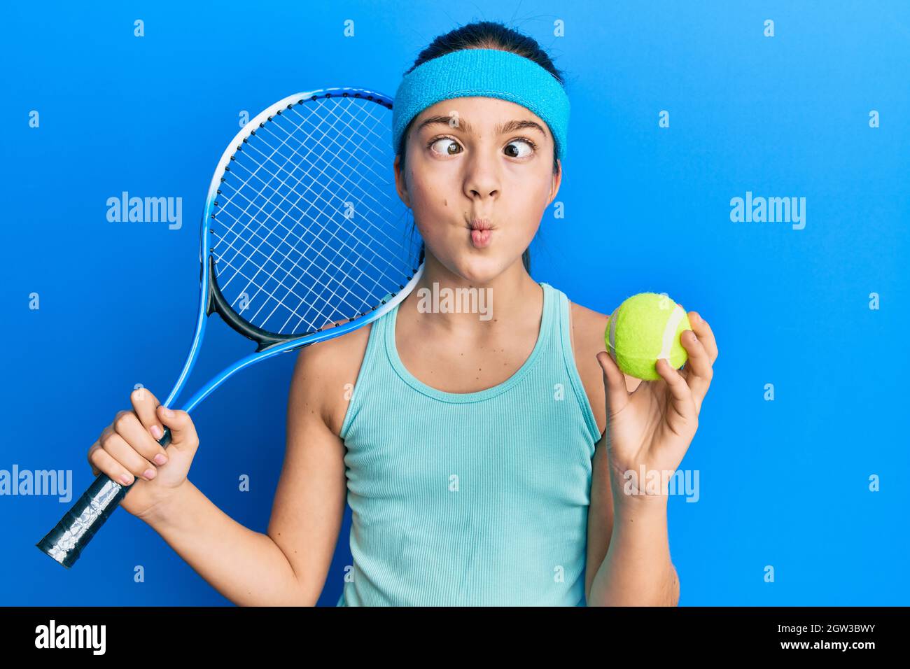 Beautiful brunette little girl playing tennis holding racket and ball ...