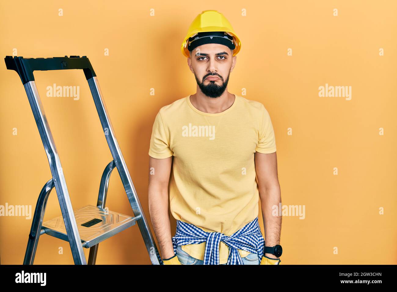 Handsome man with beard by construction stairs wearing hardhat ...