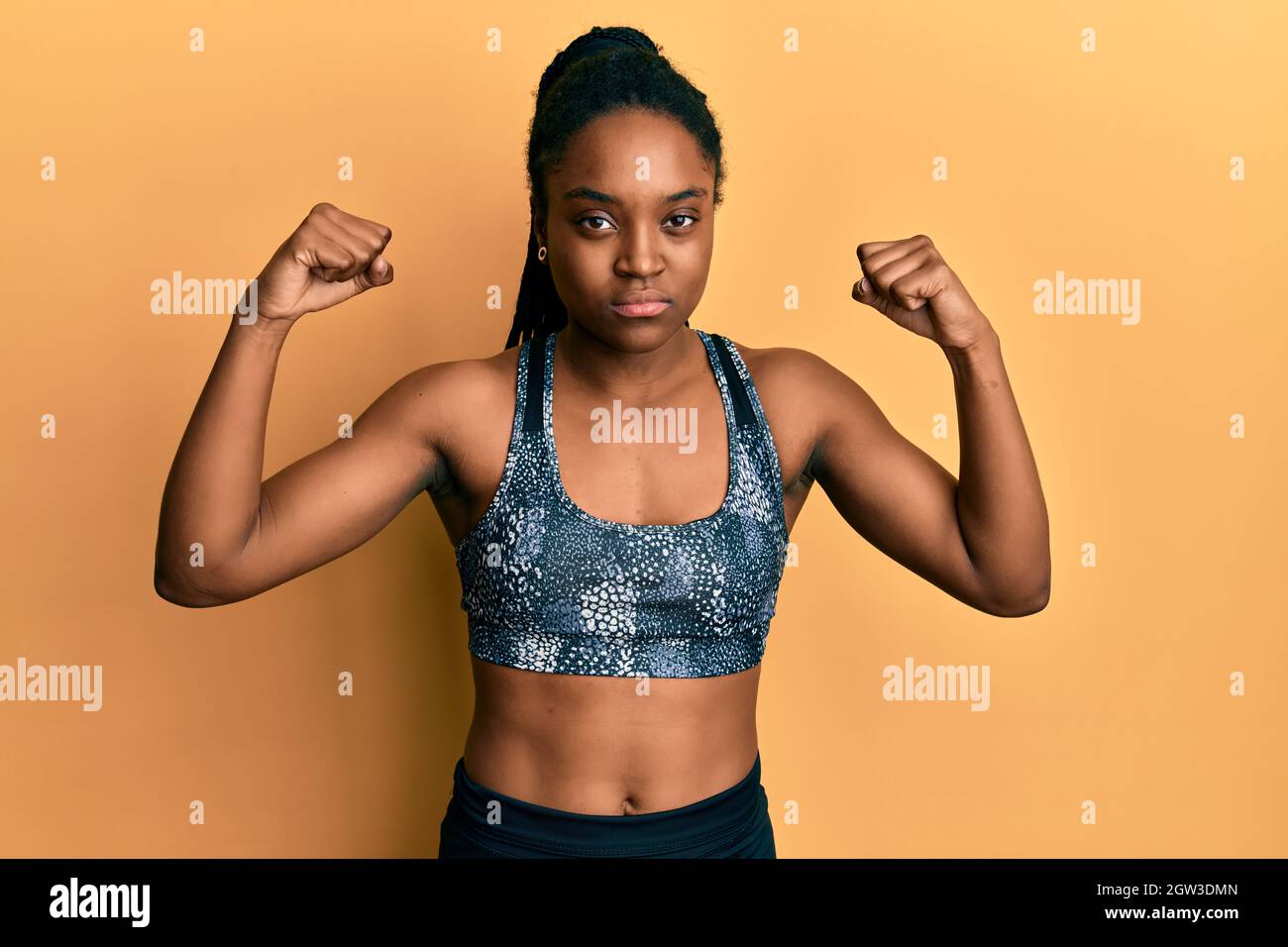 African american woman with braided hair wearing sportswear showing arm ...