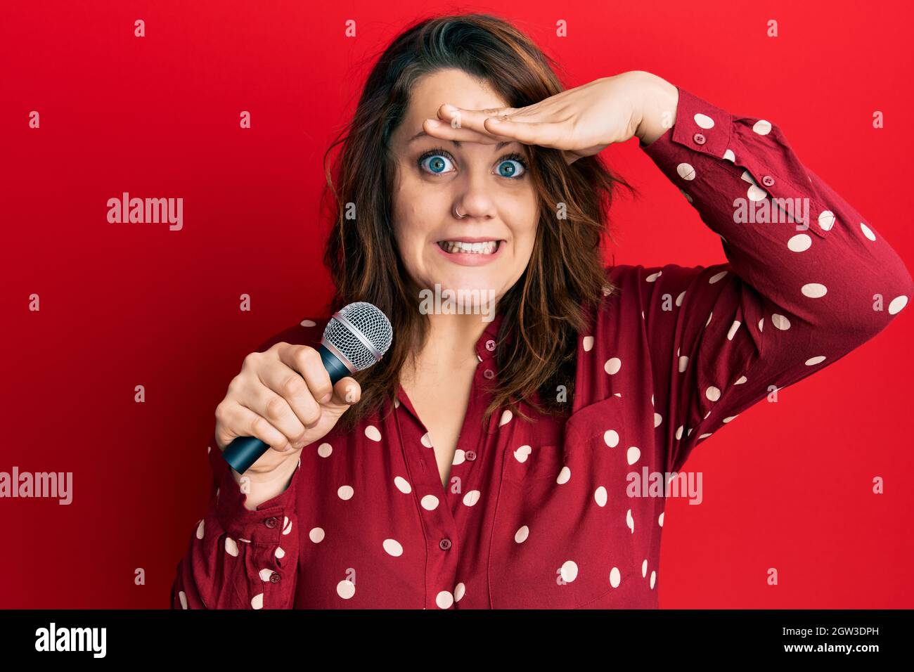 Young caucasian woman singing song using microphone stressed and ...
