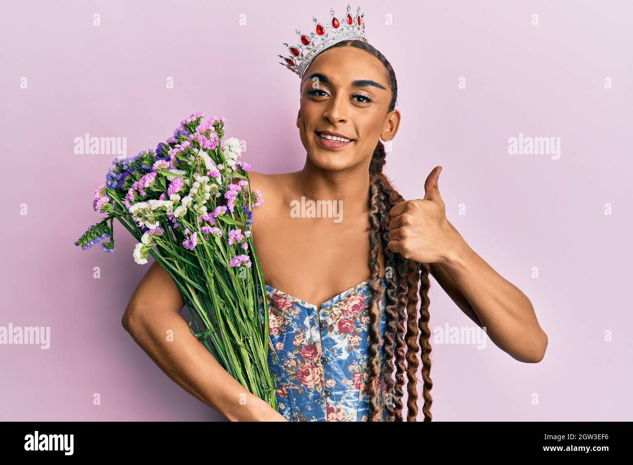 Hispanic man wearing make up and long hair wearing princess crown ...