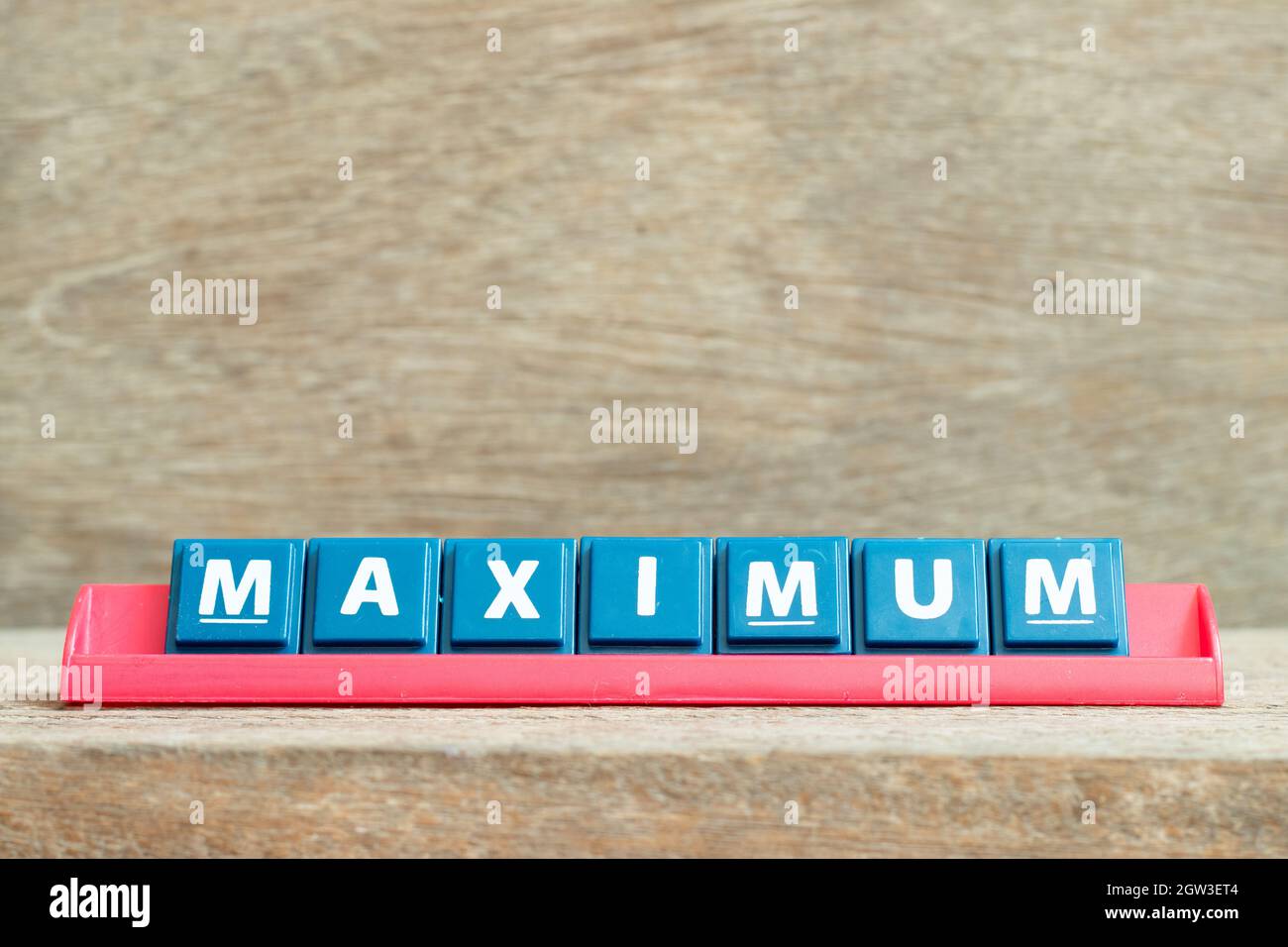Tile alphabet letter with word maximum in red color rack on wood ...