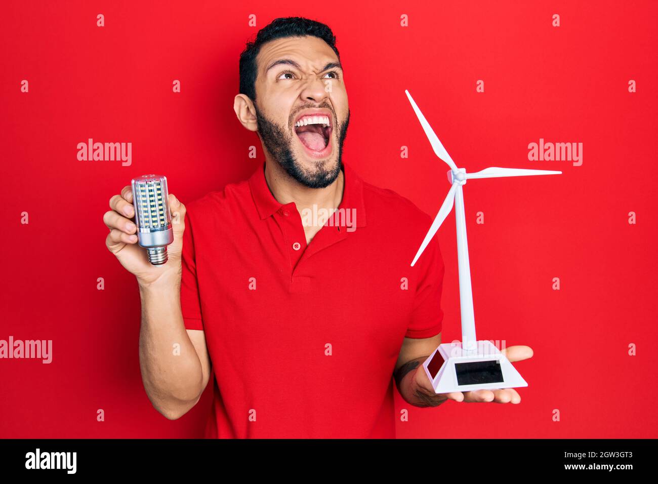 Hispanic man with beard holding solar windmill for renewable ...