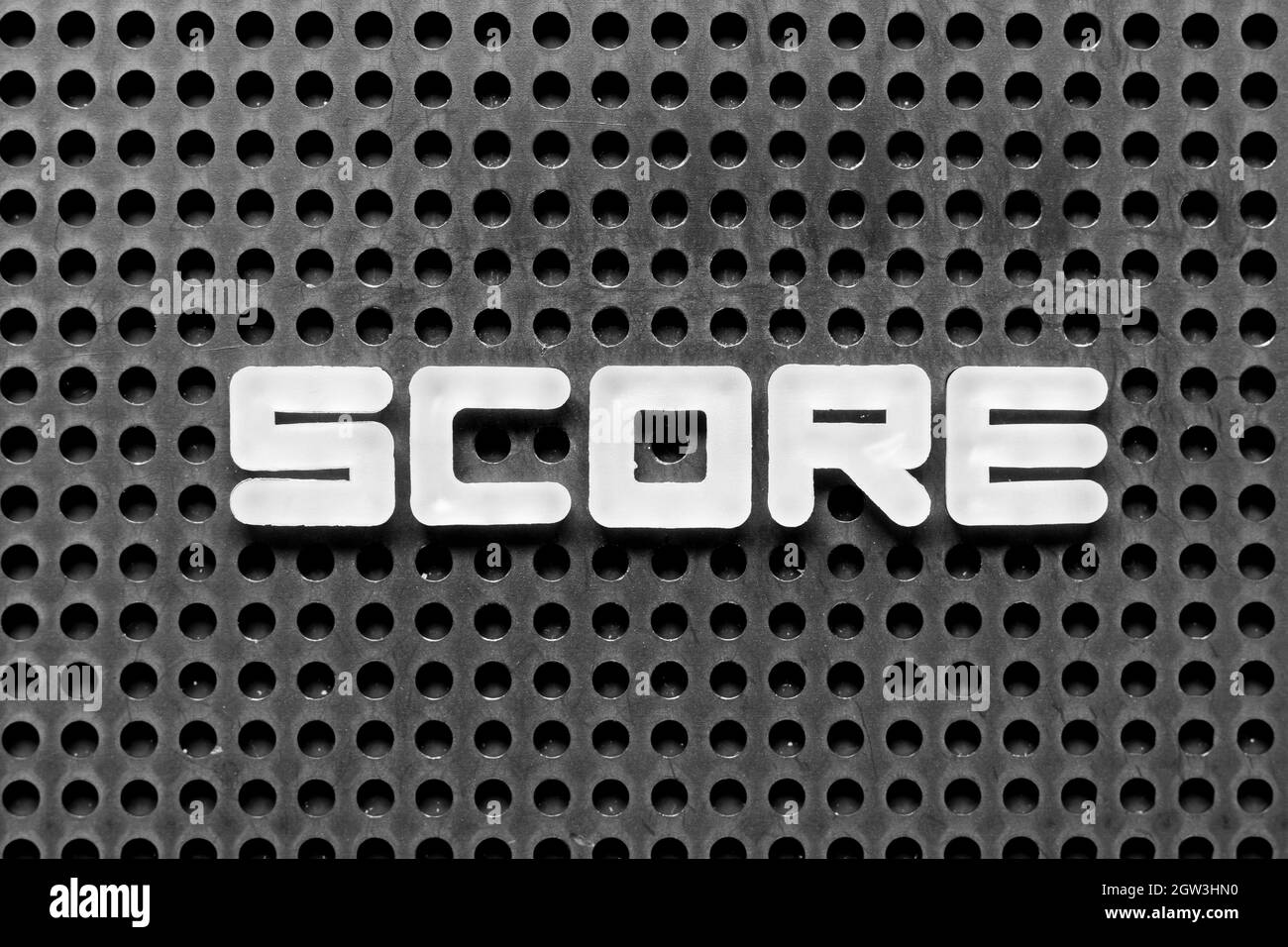 White alphabet letter in word score on black pegboard background Stock ...