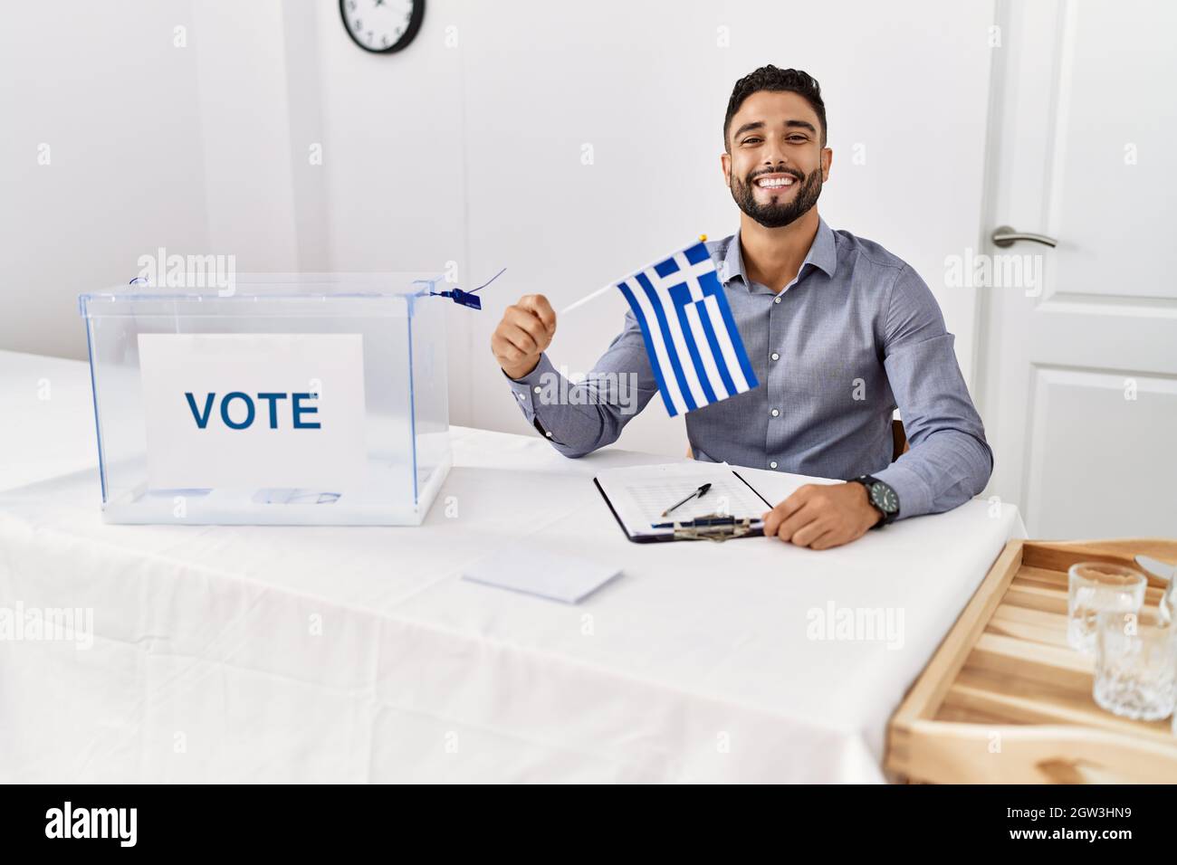 Young handsome man with beard at political campaign election holding ...