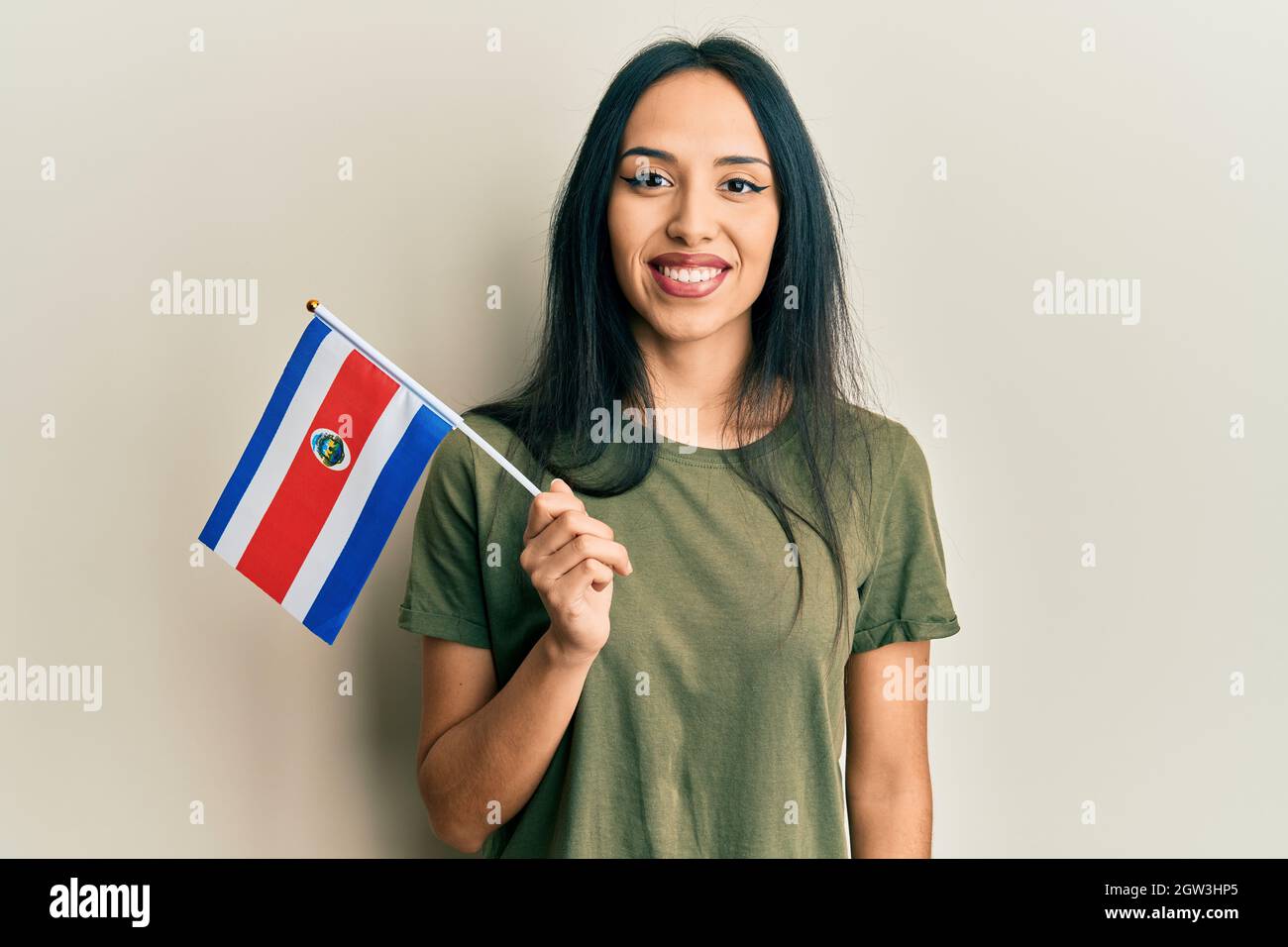 Young hispanic girl holding costa rica flag looking positive and happy ...