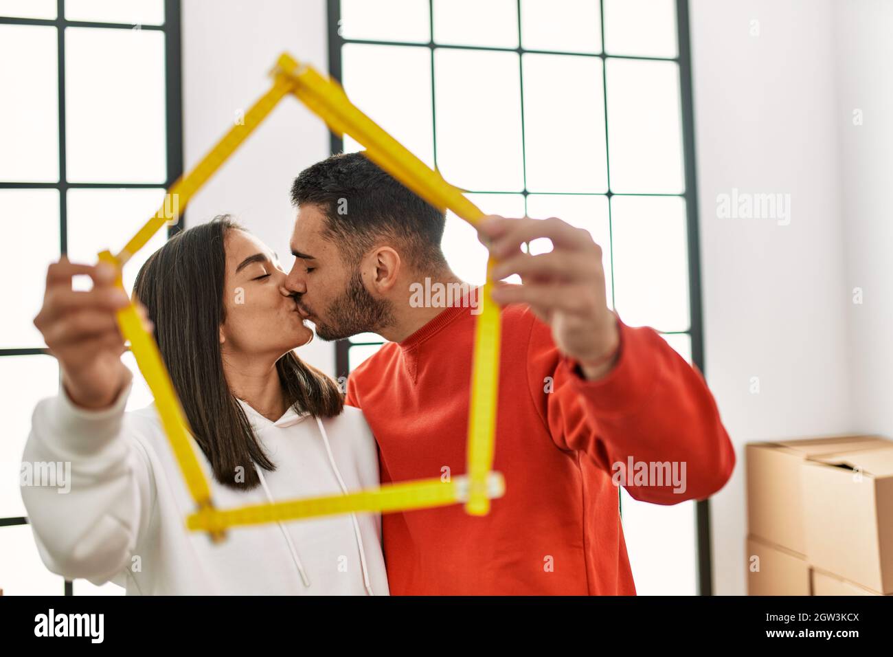 Young latin couple kissing and holding house project new home Stock ...
