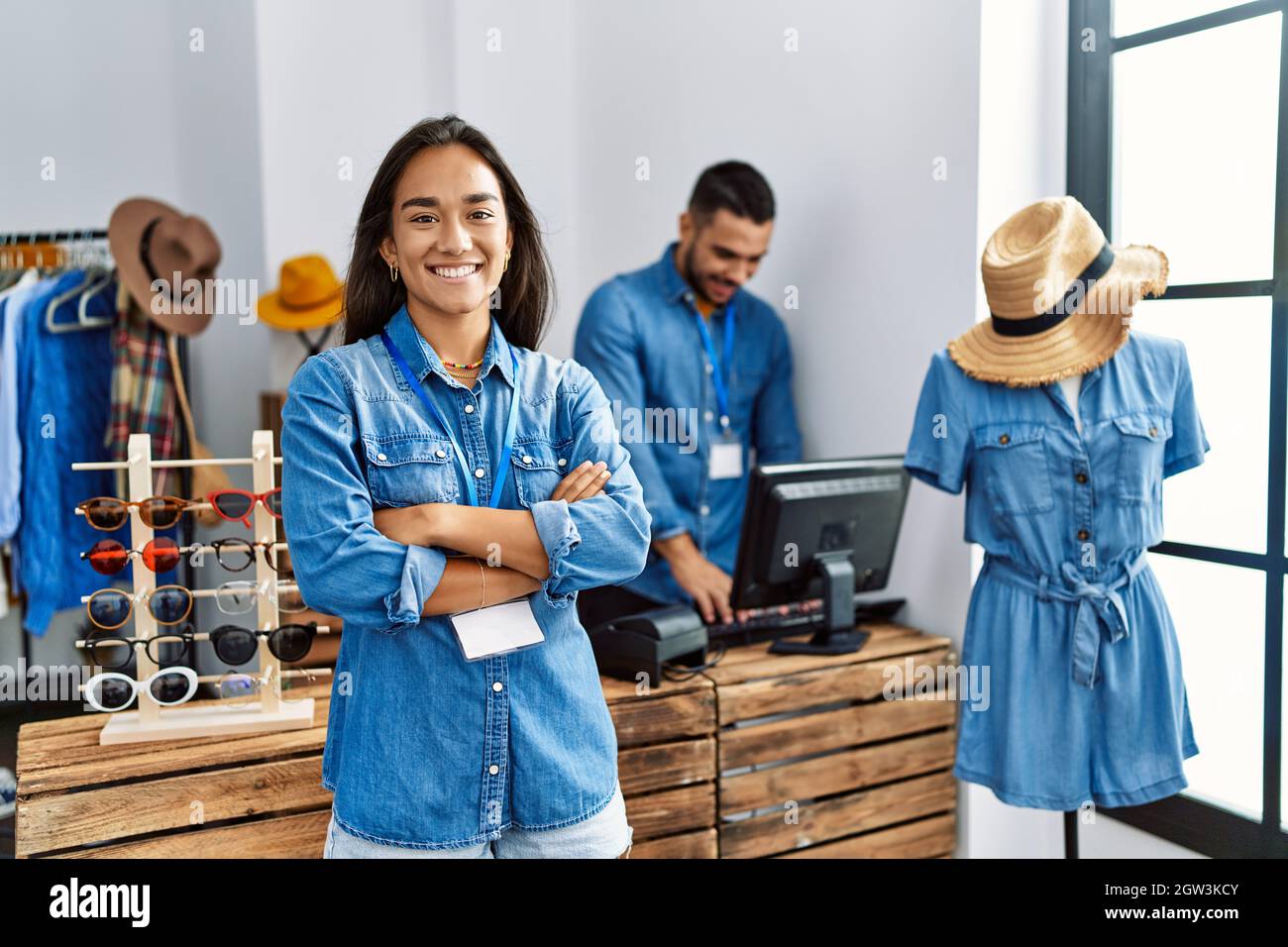 Two latin shopkeepers working at clothing store. Woman smiling happy ...