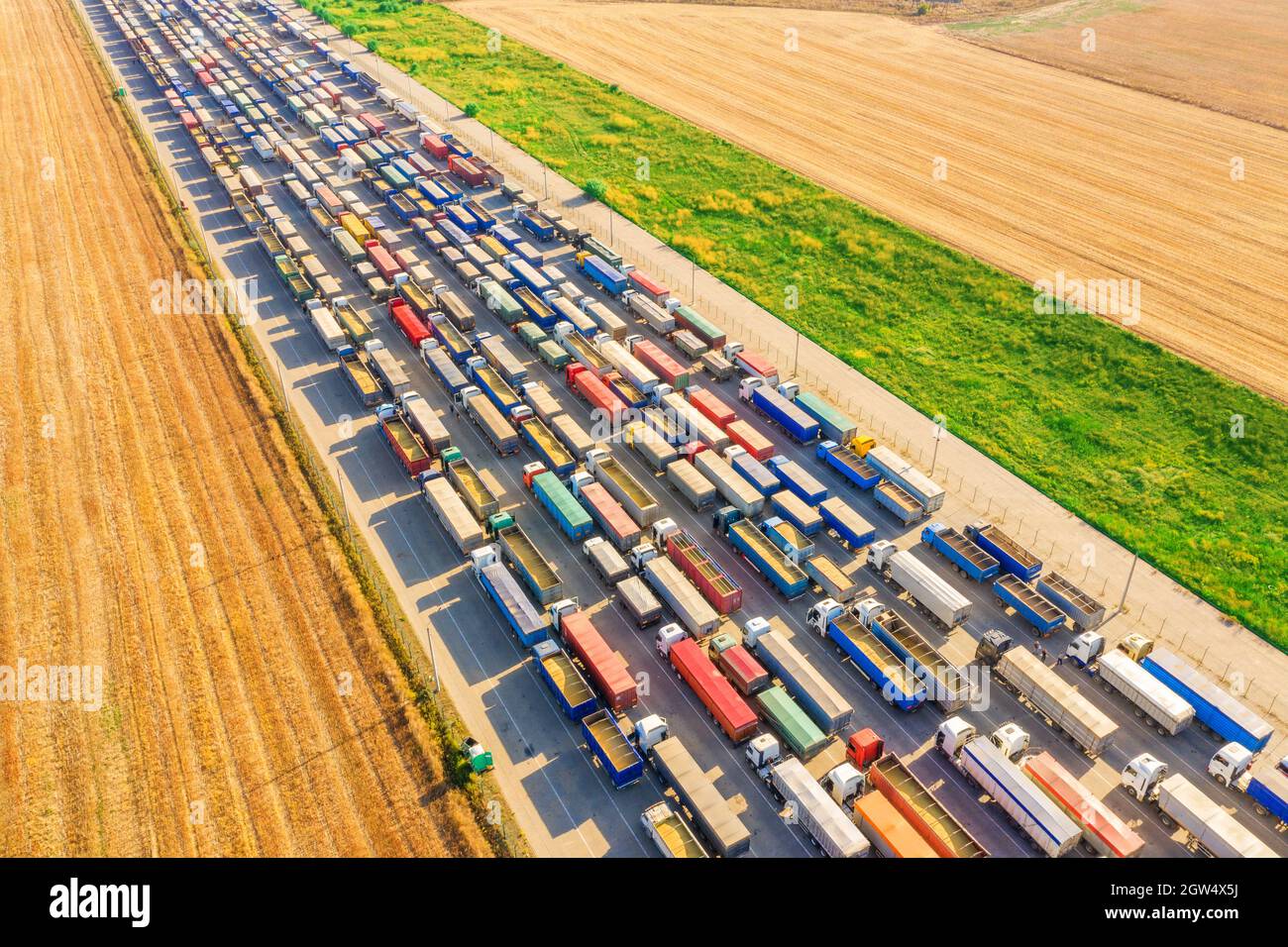 Multicolored trucks near the port terminal are waiting to be loaded or ...