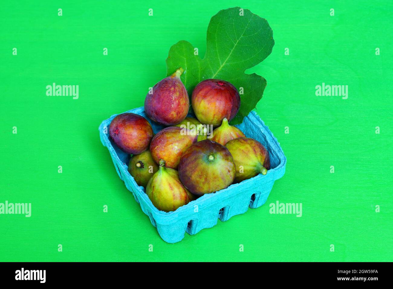 Small container of fresh ripe purple and green figs Stock Photo - Alamy