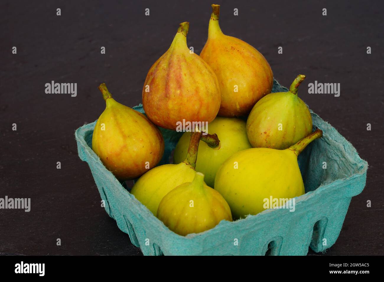 Small container of fresh ripe purple and green figs Stock Photo - Alamy