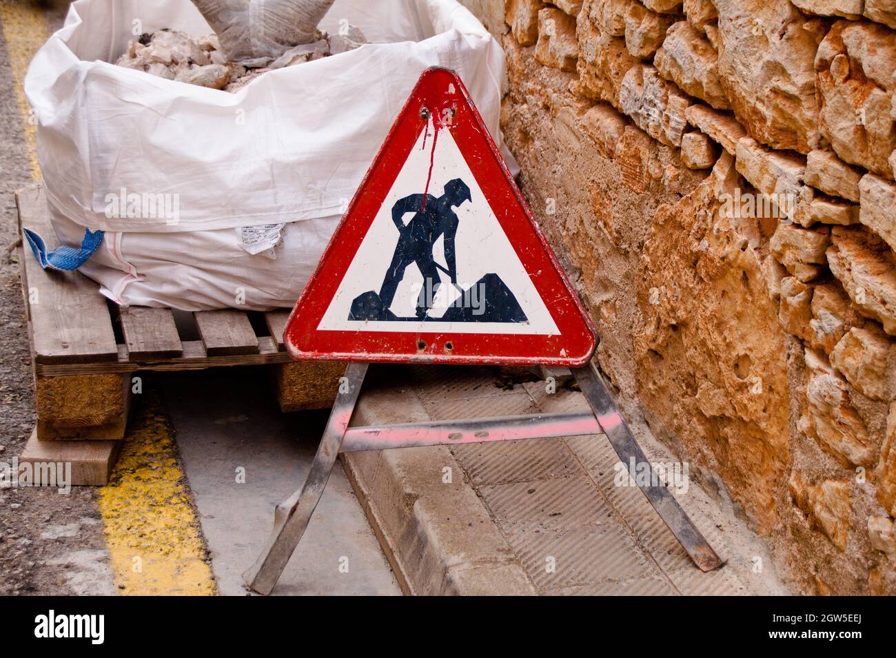 Road Sign During Construction By Stone Wall Stock Photo - Alamy