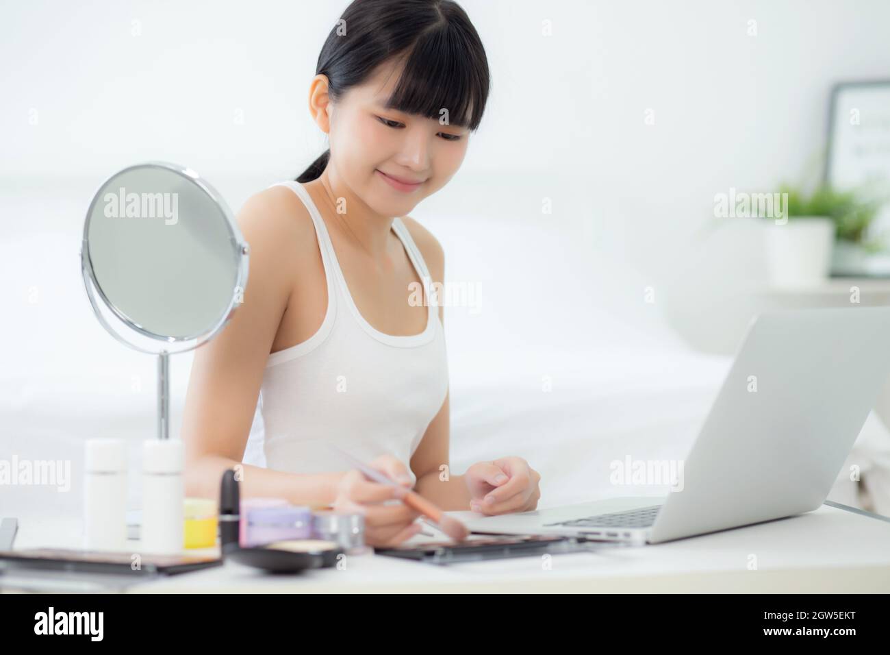 Beauty of young asian woman with learning makeup with brush on cheek on ...