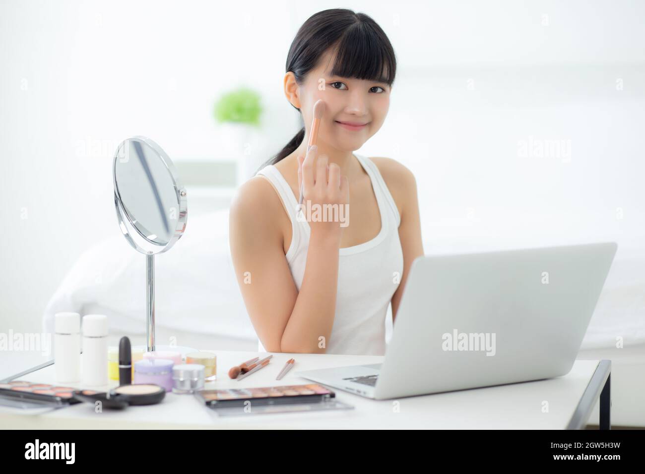 Beauty of young asian woman with learning makeup with brush on cheek on ...