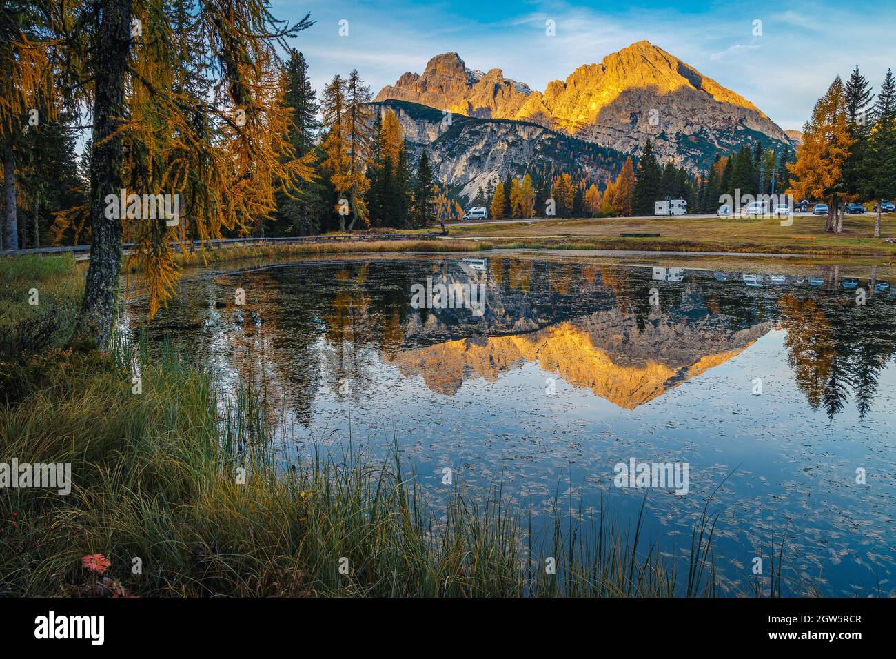 Breathtaking dawn autumn landscape, mountain lake and colorful larches ...