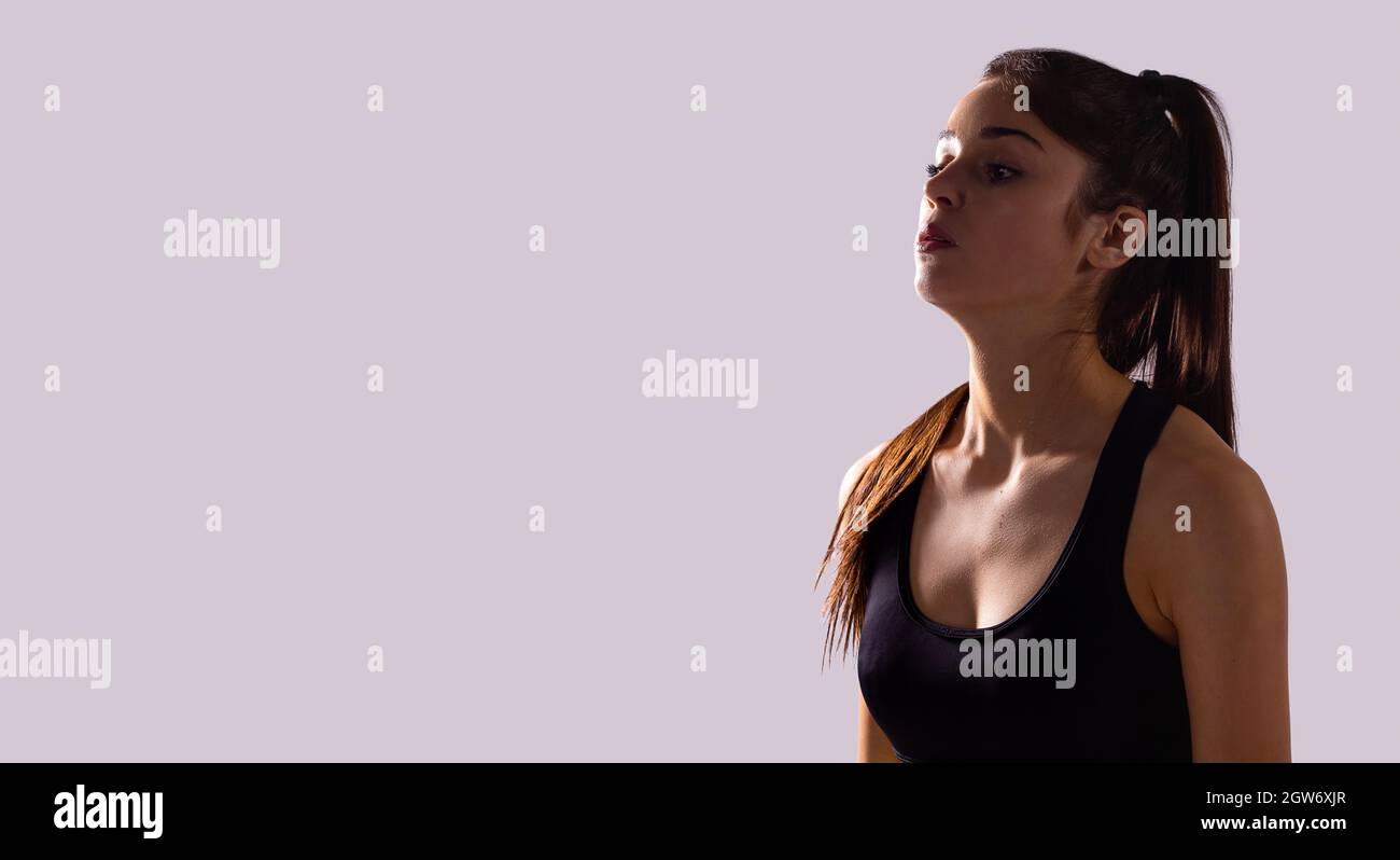 The profile pose of a attractive sporty girl in a black top sports ...