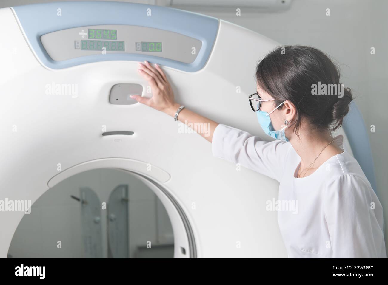 woman x-ray doctor adjusting computer tomography scanner machine to ...