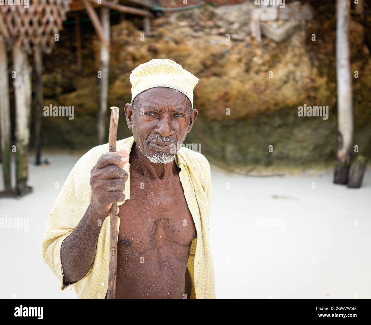 Aged African shepard walking on the beach holding stick Stock Photo - Alamy