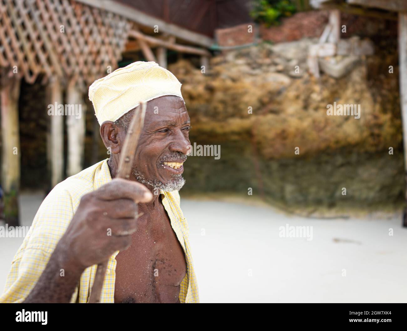Aged African shepard walking on the beach holding stick Stock Photo - Alamy