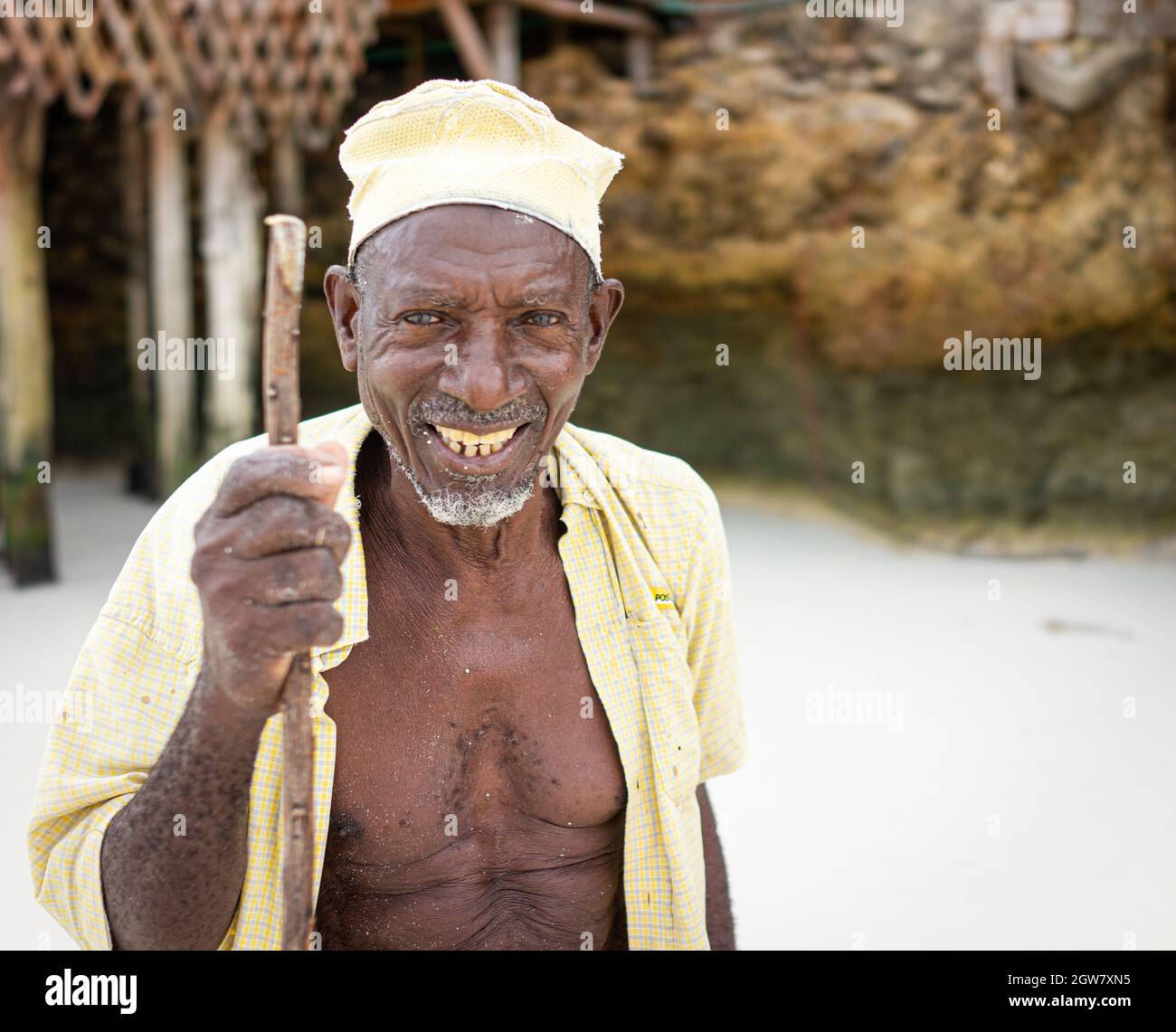 Aged African shepard walking on the beach holding stick Stock Photo - Alamy