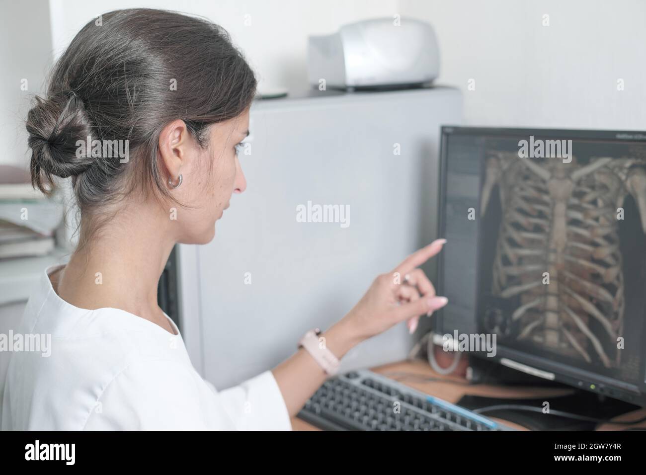 middle east woman doctor looking at monitor with chest bones computer ...
