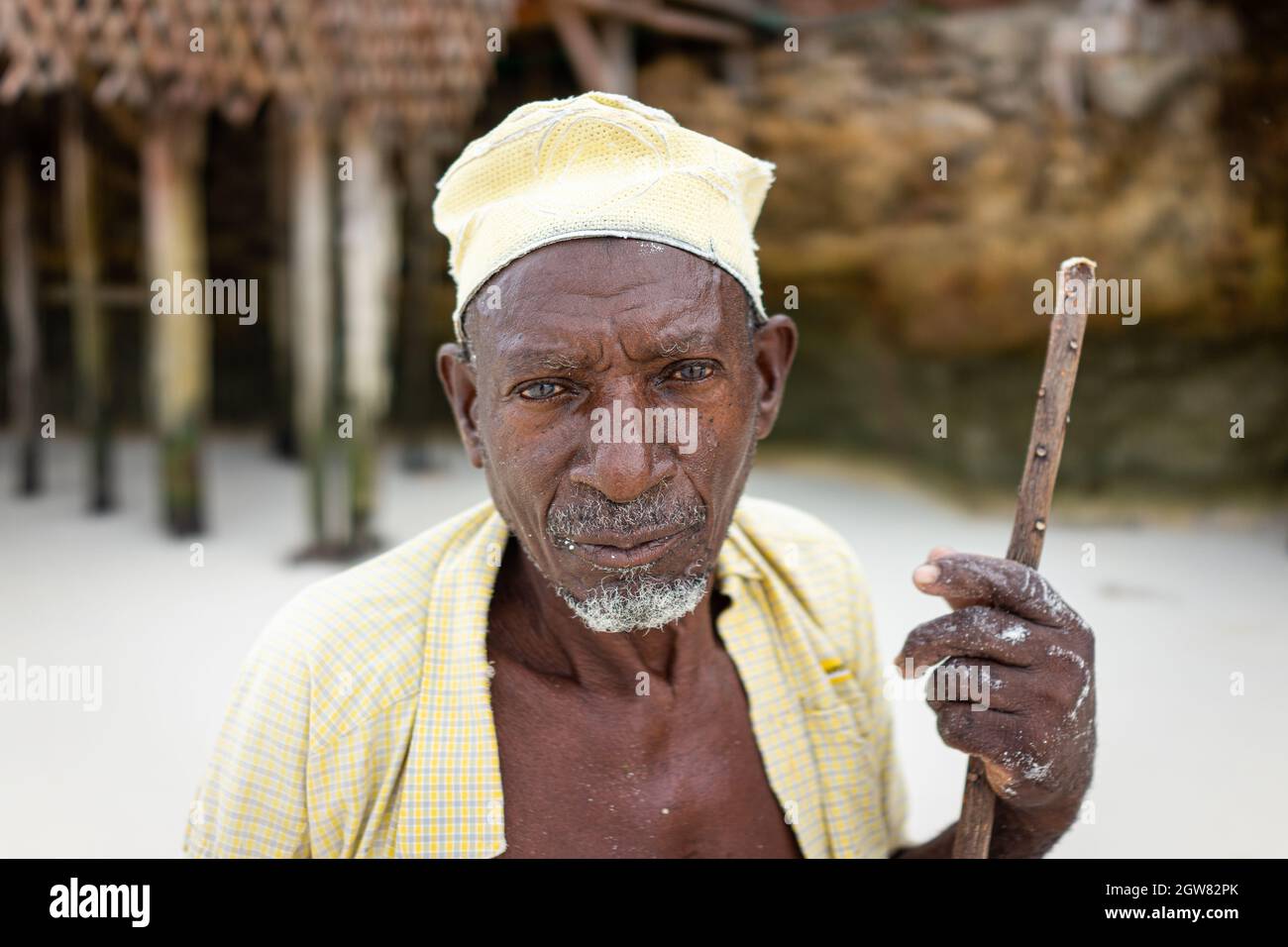 Aged African shepard walking on the beach holding stick Stock Photo - Alamy