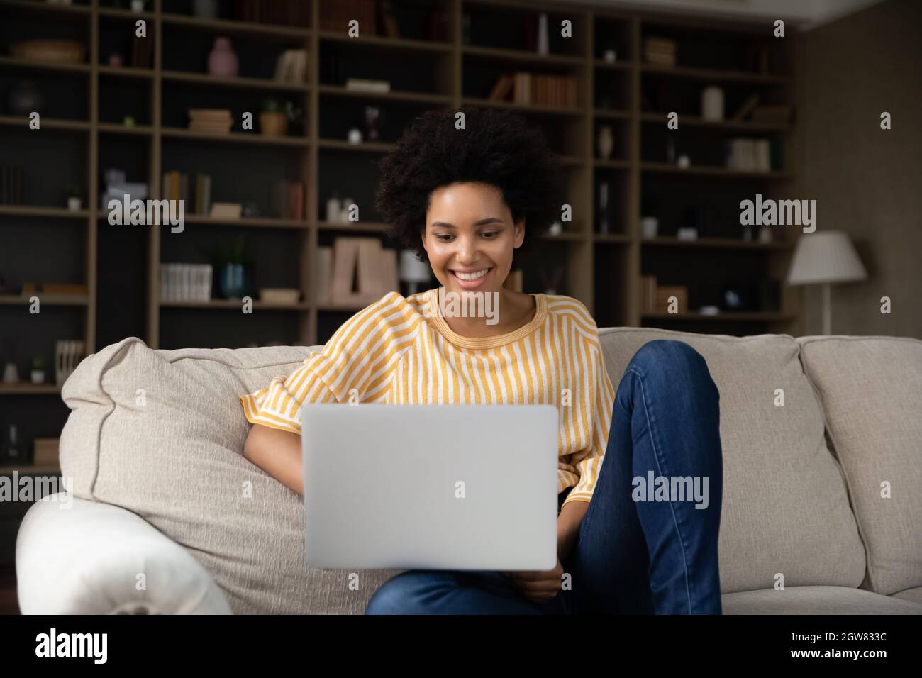 Happy young african american woman using computer Stock Photo - Alamy