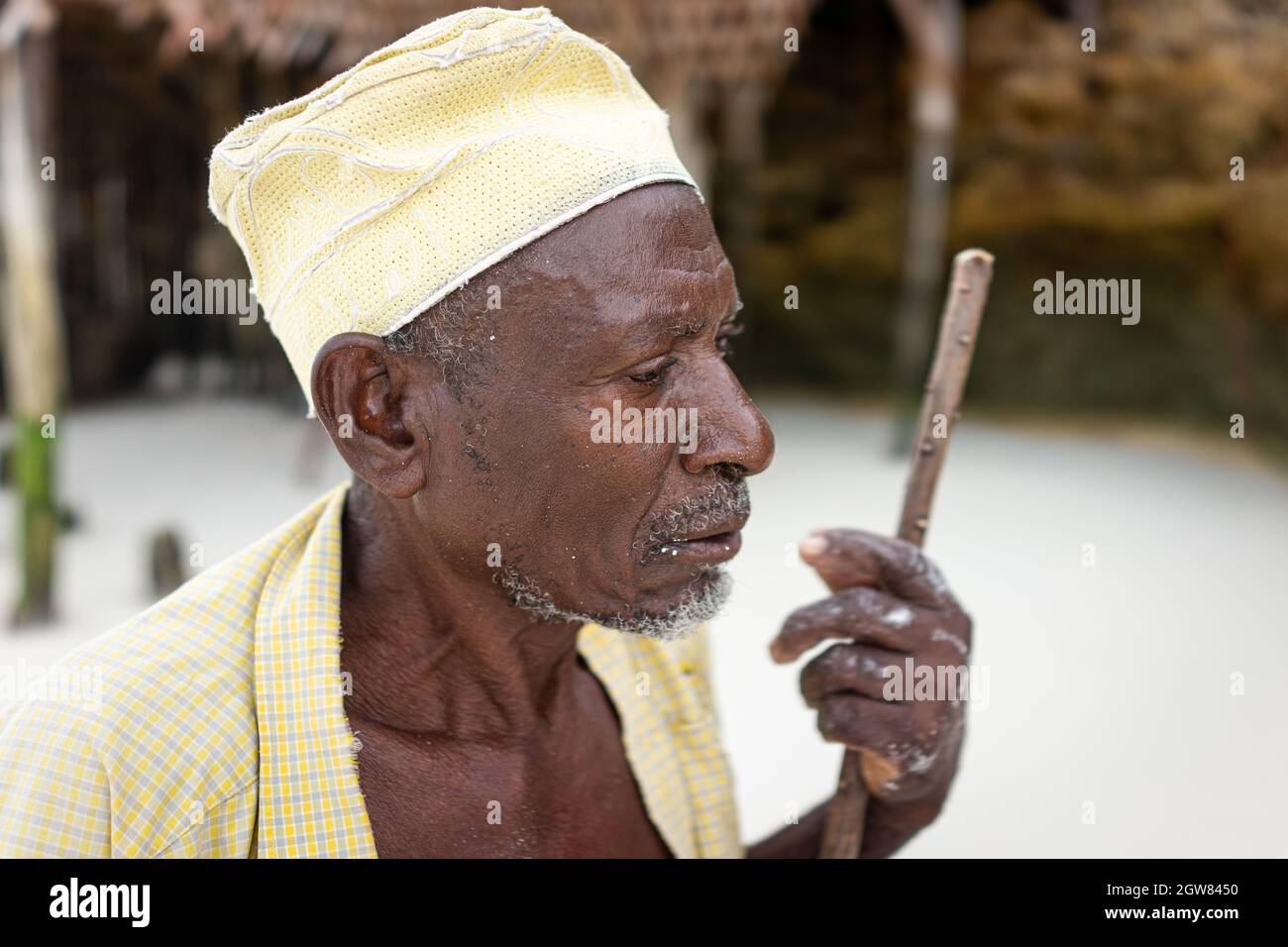 Aged African shepard walking on the beach holding stick Stock Photo - Alamy