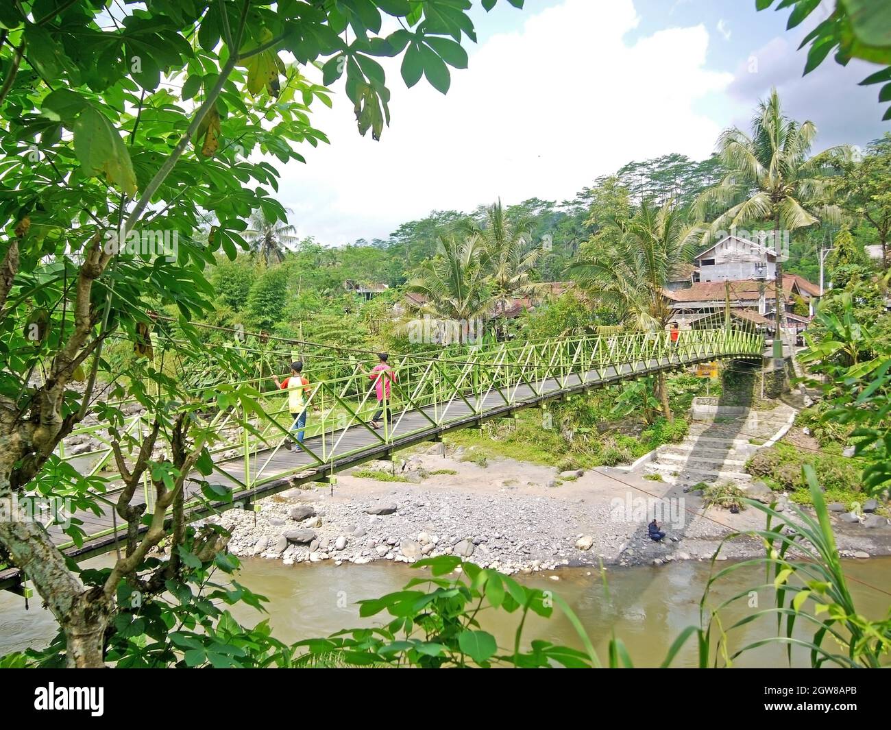 a green bridge over the river that connects two villages in Wonosobo ...