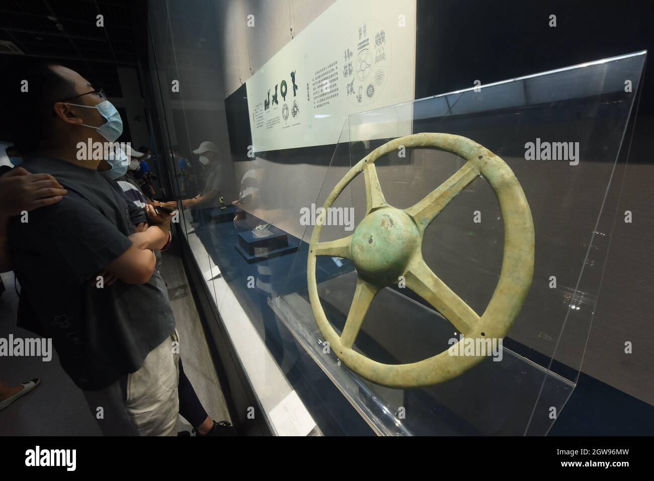HANGZHOU, CHINA - OCTOBER 3, 2021 - Visitors look at a bronze sun ...