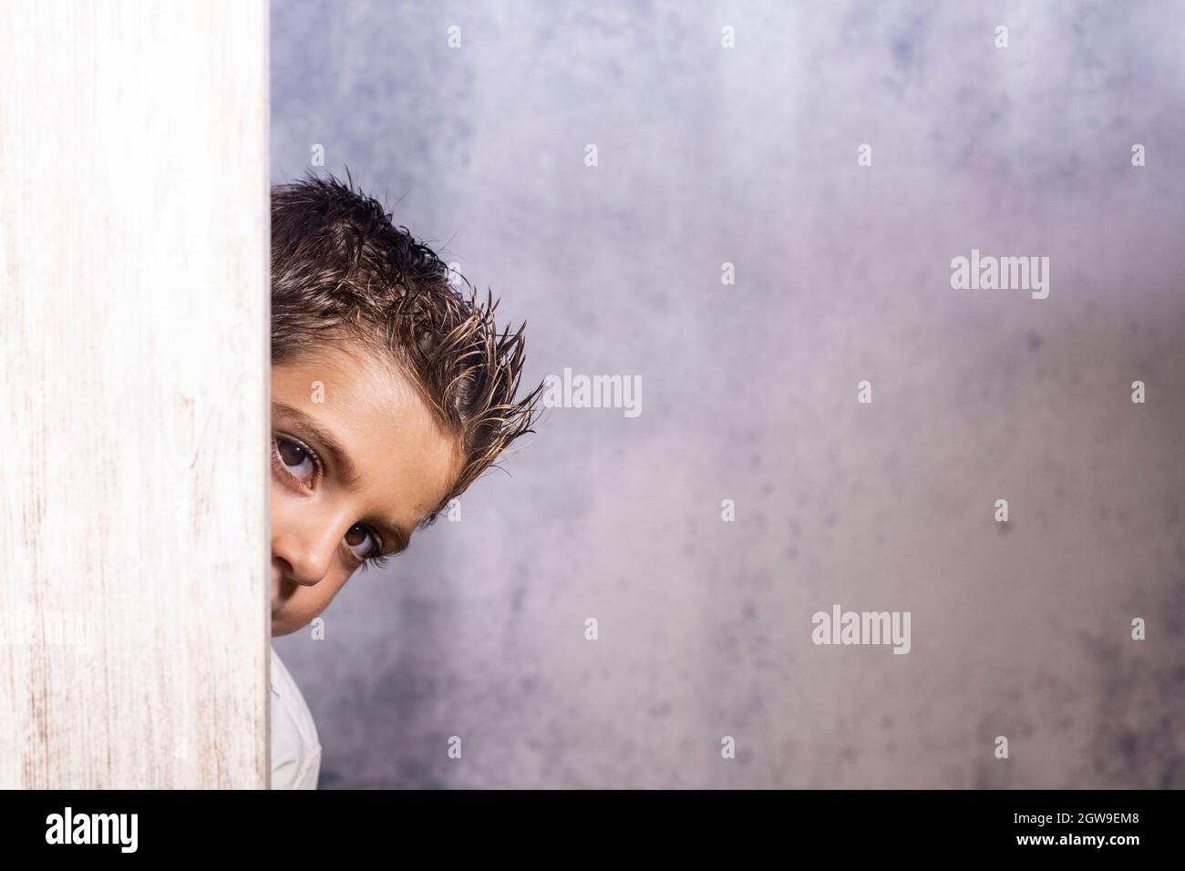 Boy hiding behind door hi-res stock photography and images - Alamy