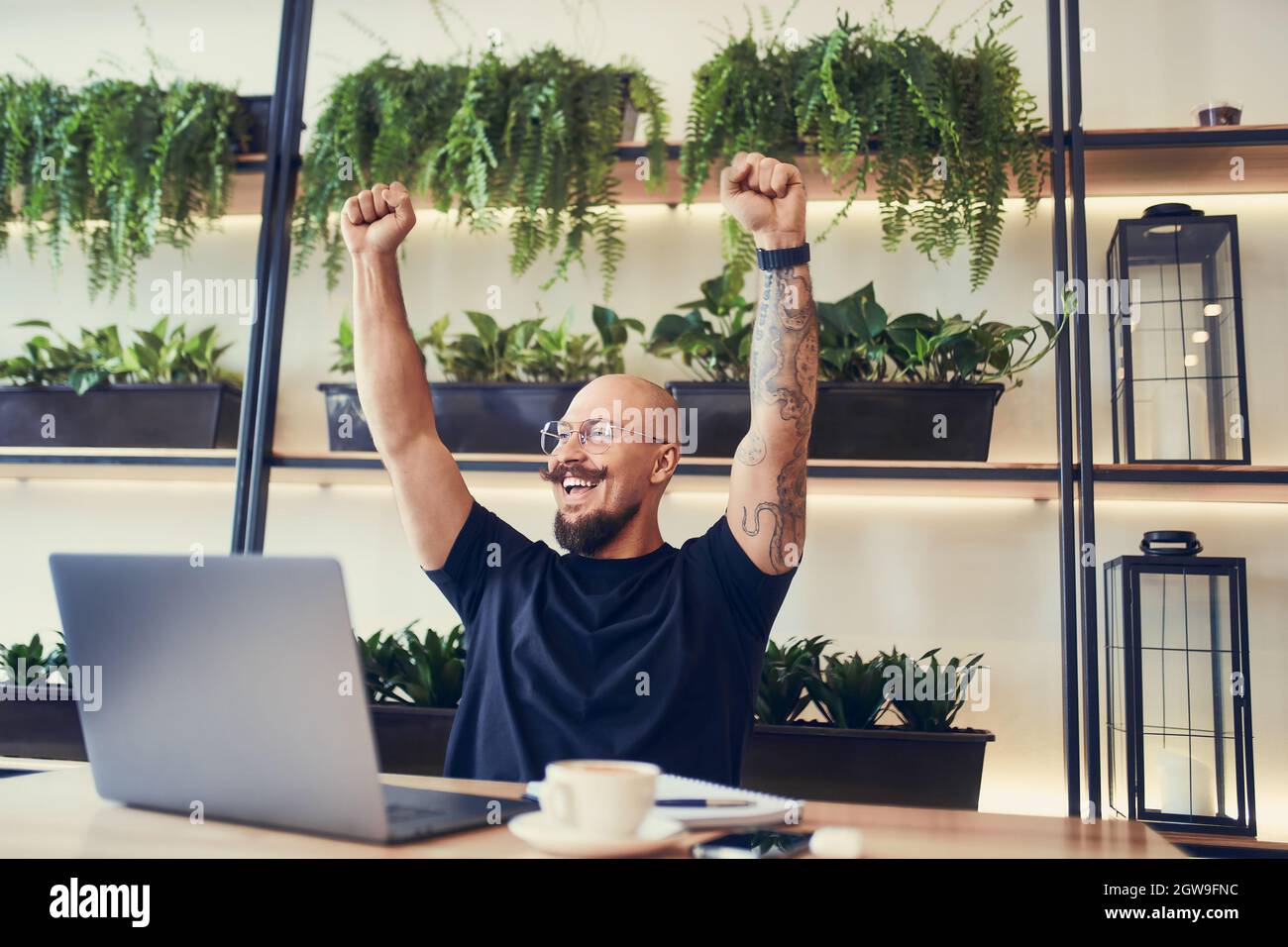 Caucasian bald man feels happy received good news by internet raised ...