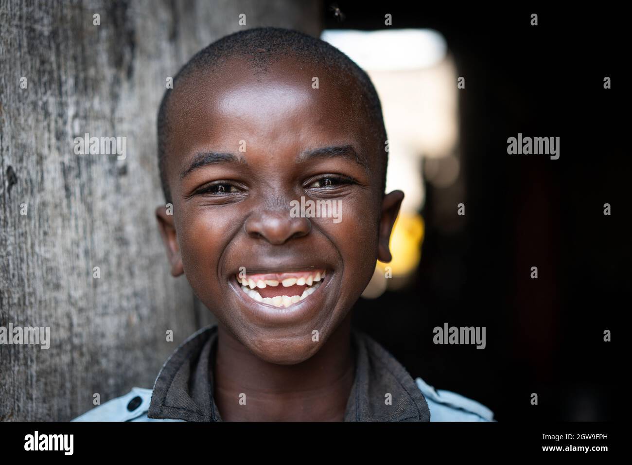 Cute happy poor black child at home Stock Photo - Alamy