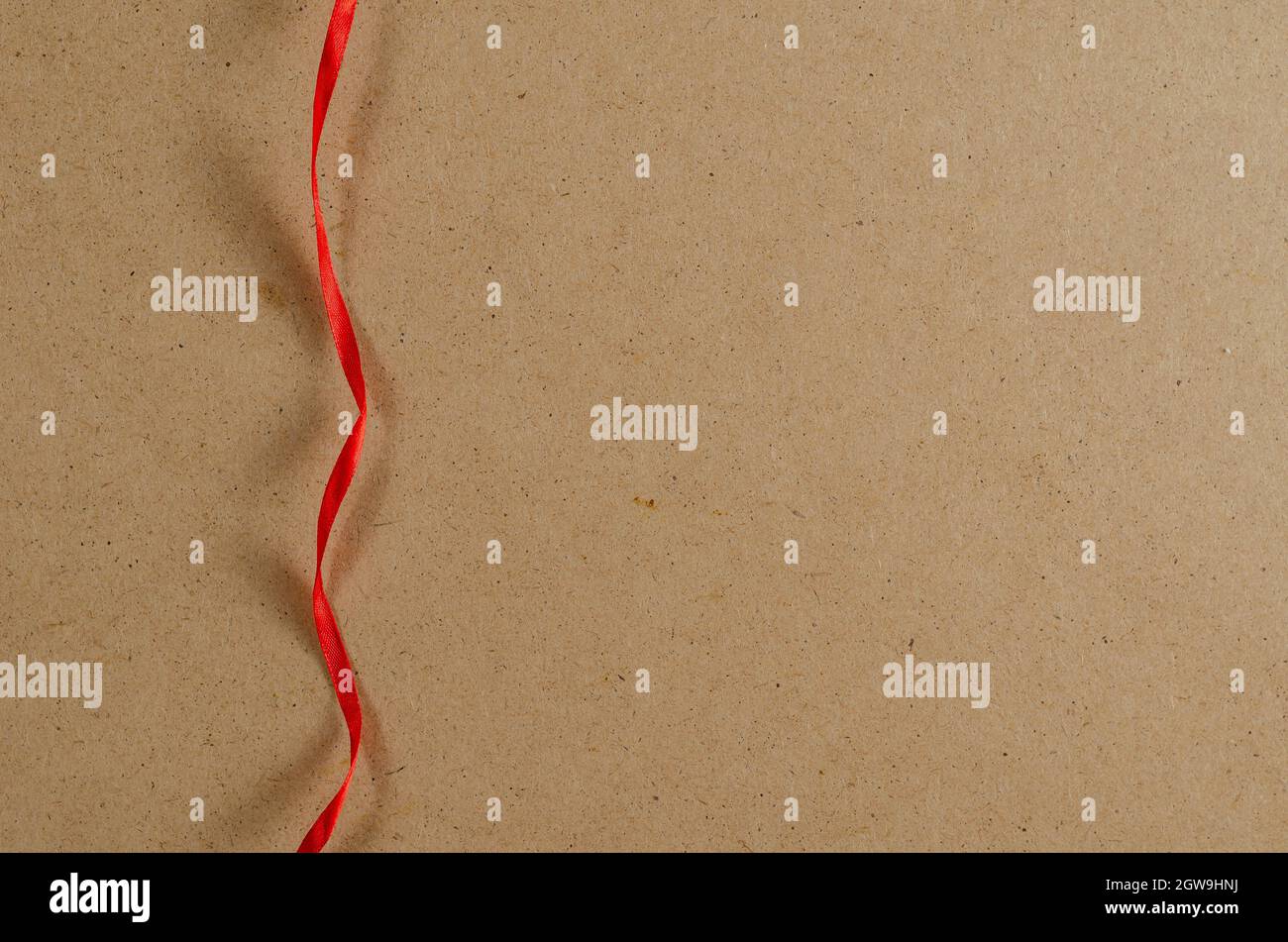 A thin red ribbon vertically against the brown background. Side view ...