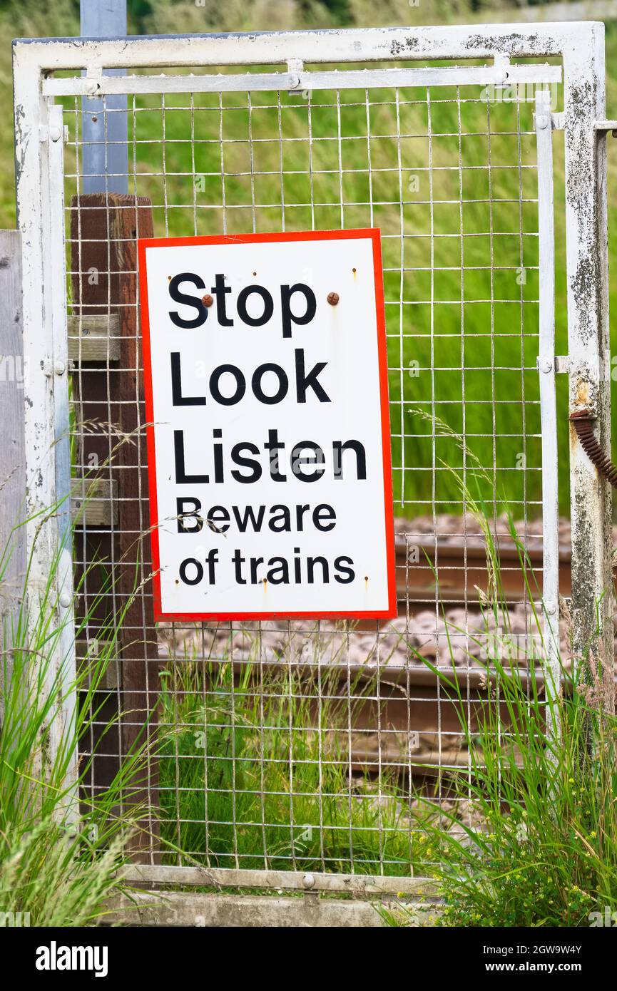 Stop look listen safety road sign at railway train station danger ...