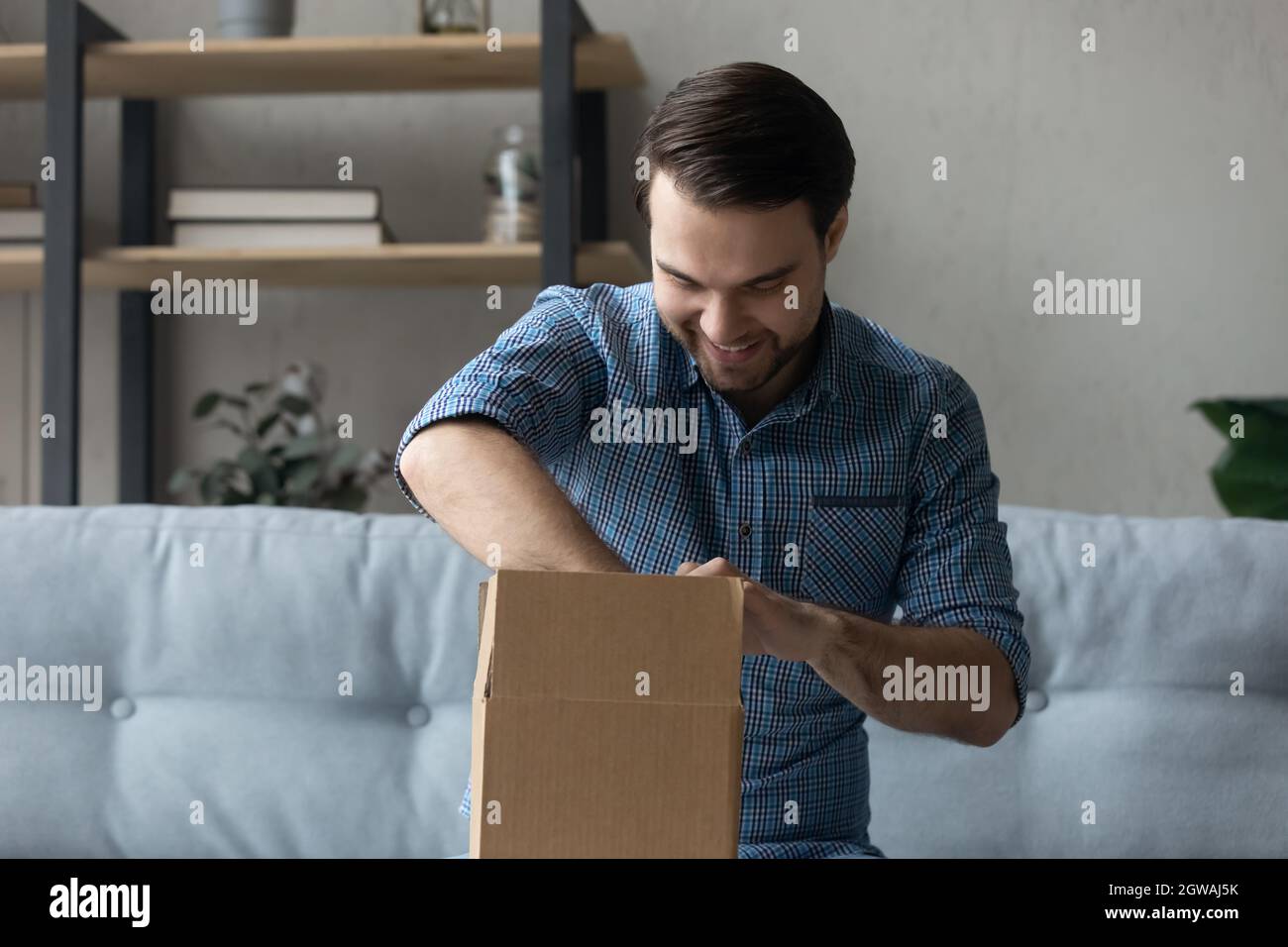 Happy man opening parcel hi-res stock photography and images - Alamy