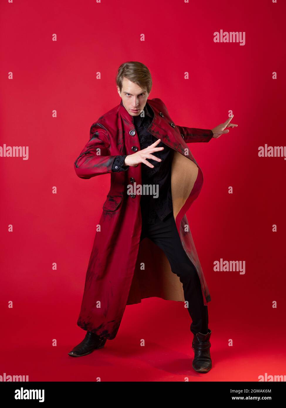 An outrageous young man in a daring red coat in a vintage noir style ...