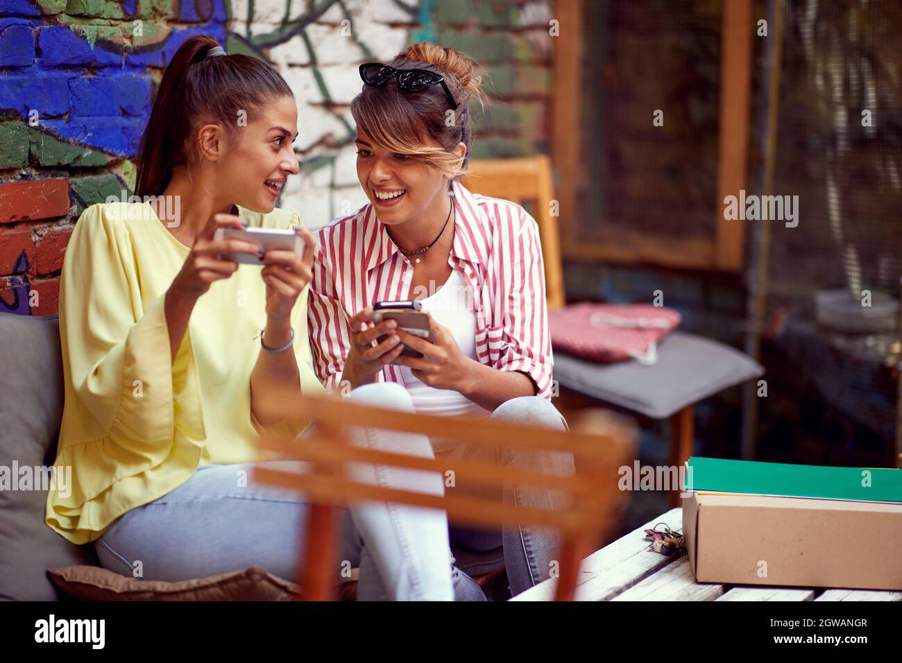 beautiful young adult female friends sharing contents on their cell ...